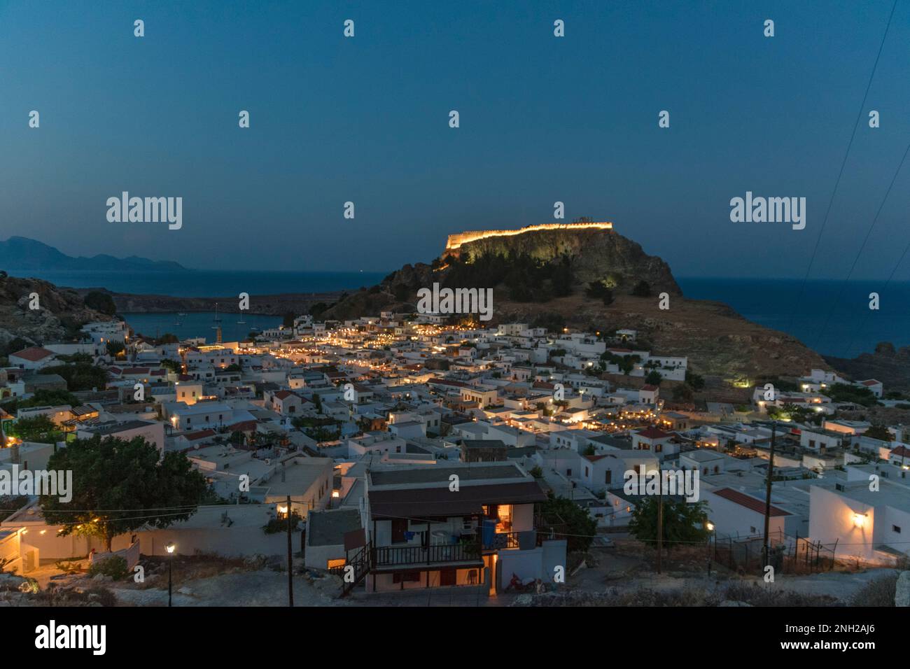 View of Lindos village and Acropolis at nightfall, Rhodes Stock Photo ...