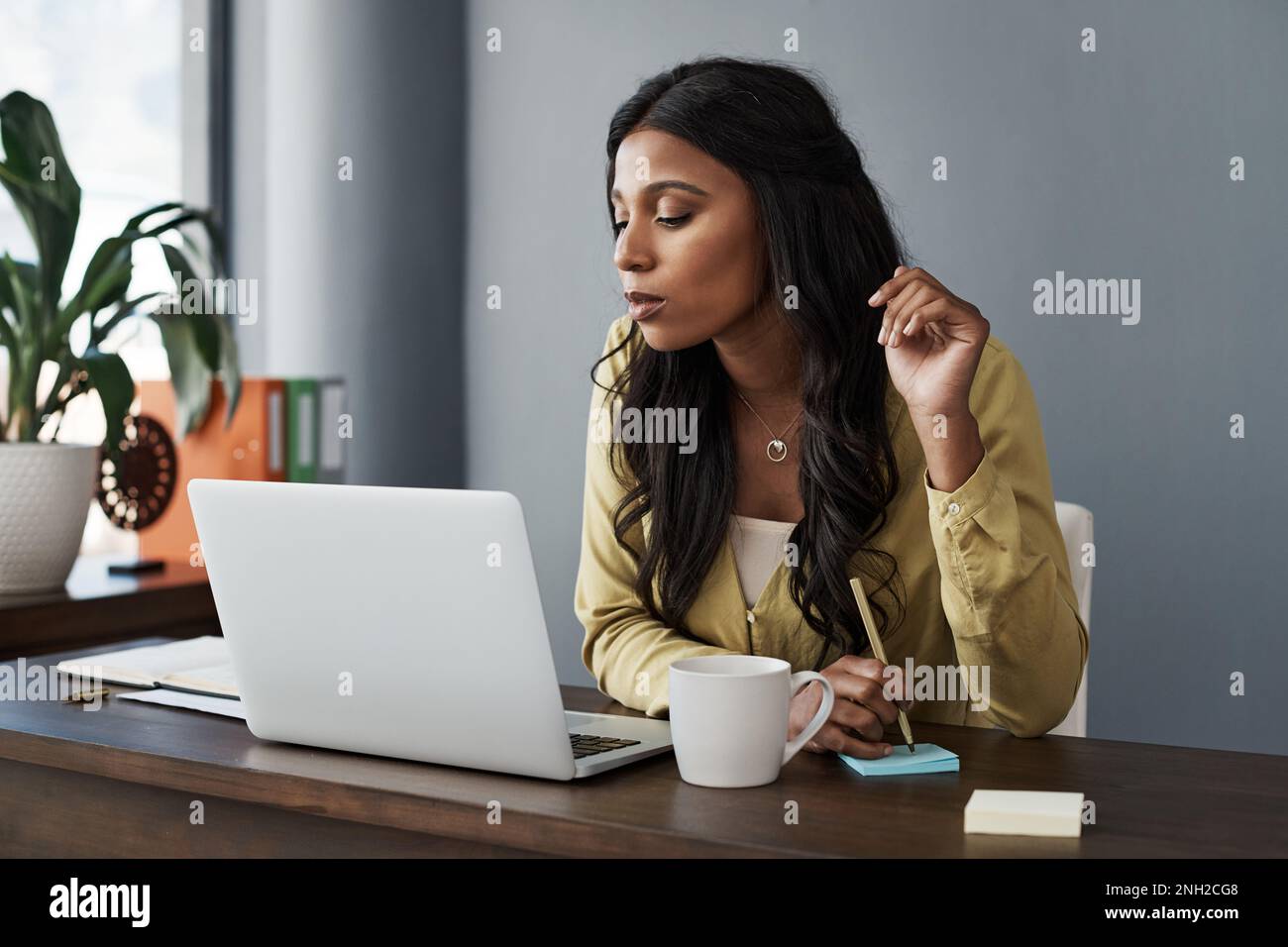 Always take notes to remember great ideas. a young businesswoman taking ...