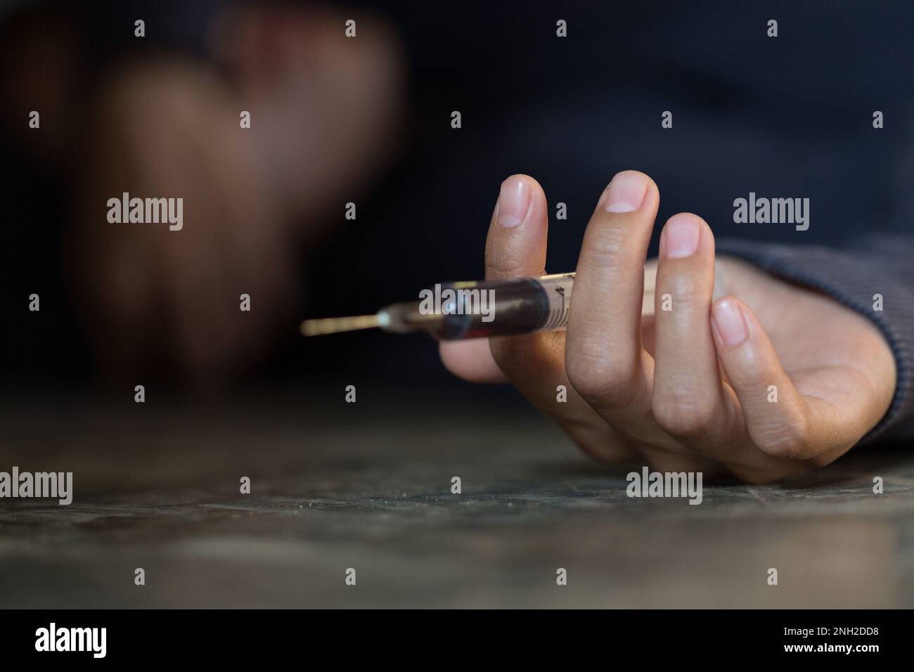 Young woman hand holding a syringe and drug overdose,The concept of ...