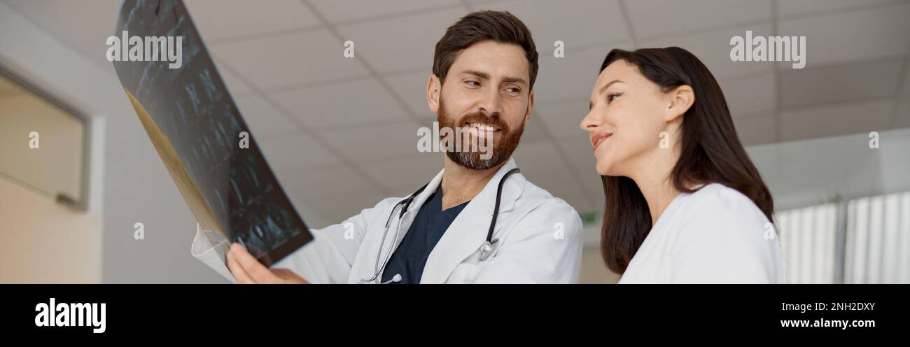 Two doctors in uniform look and discuss an X Ray or MRI scan of the ...