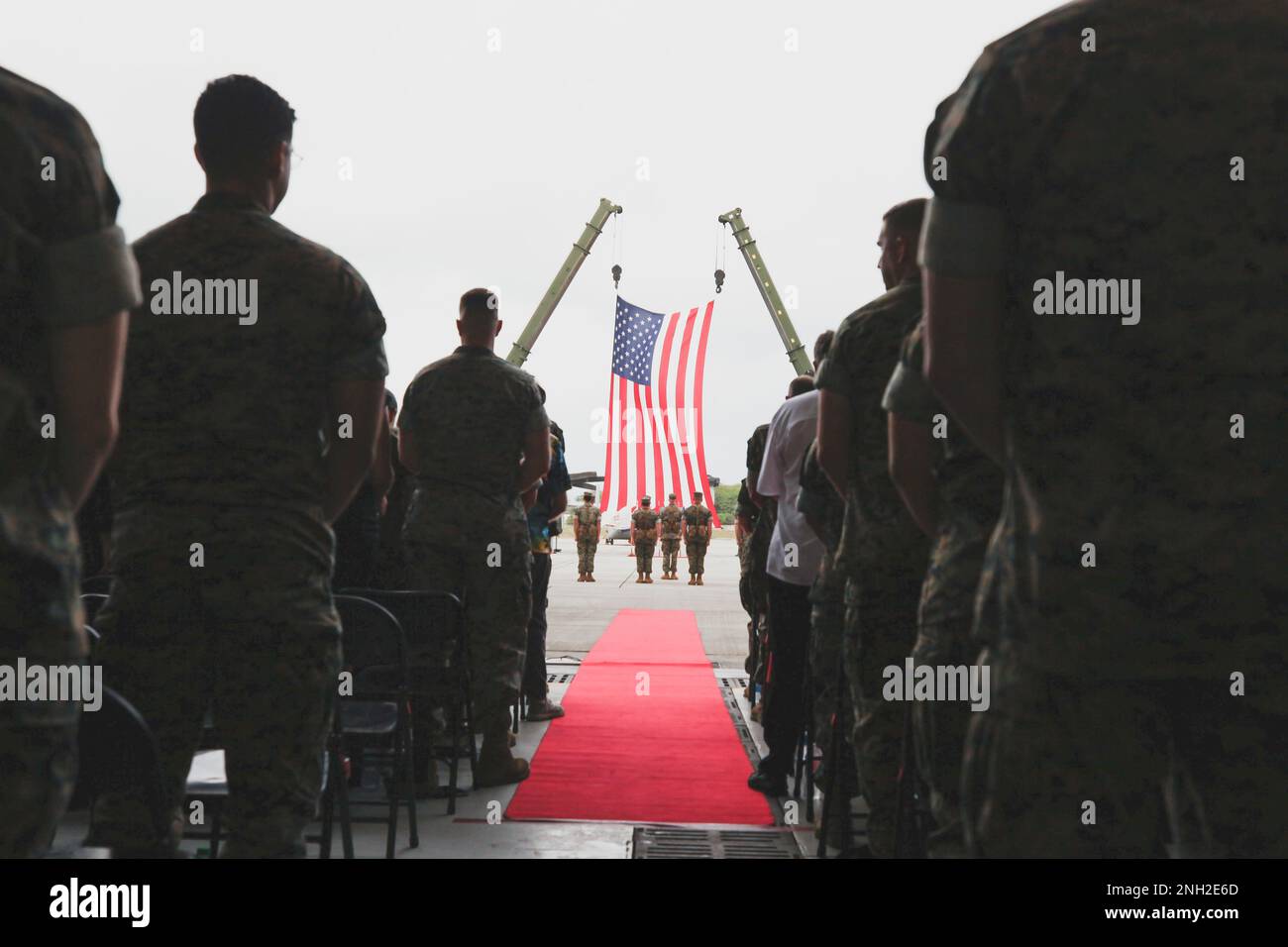 U.S. Marines and attendees stand for the national anthem during a ...