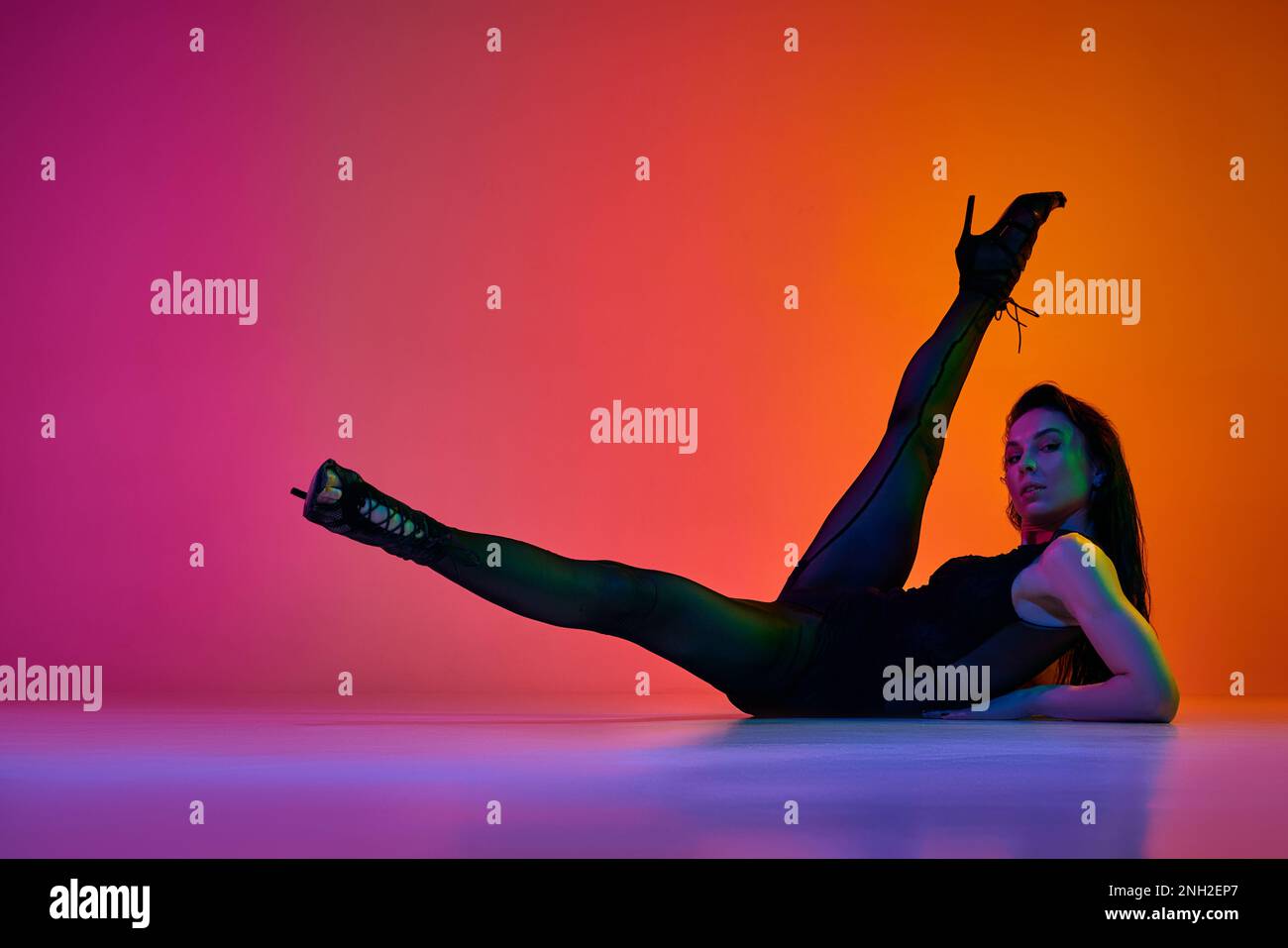 Attraction. Young woman dancing high heel dance over gradient pink ...