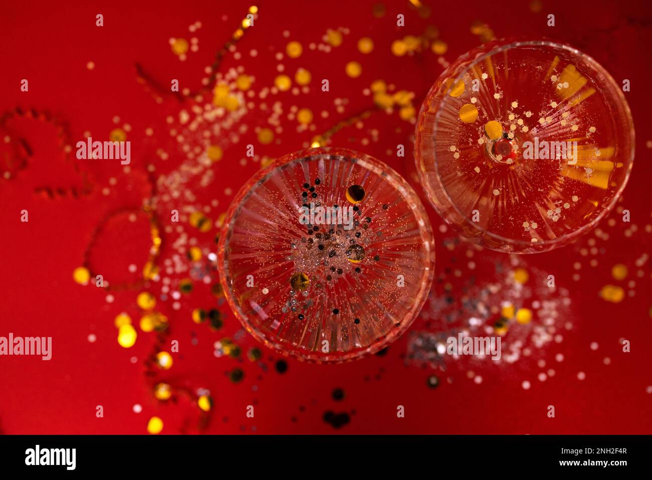 Two exquisite glasses of champagne with silver glitters and confetti ...