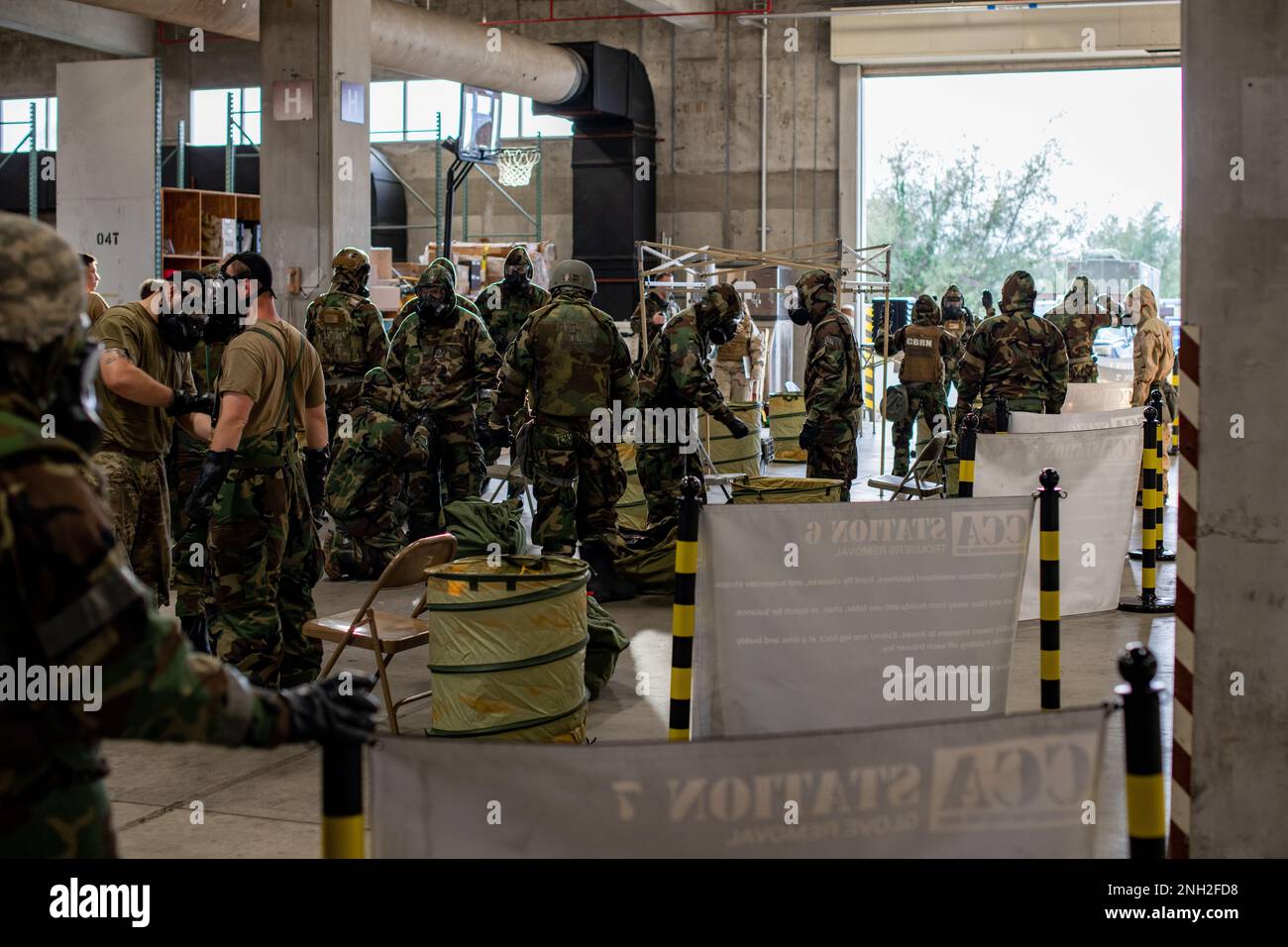 18th Wing Airmen in protective gear go through a simulated ...