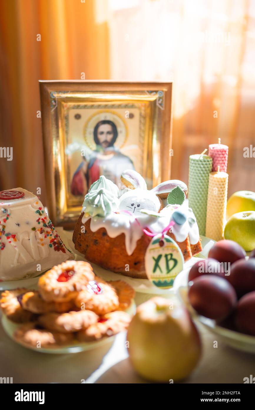 Easter cake with painted eggs, apples and cookies on table in home ...