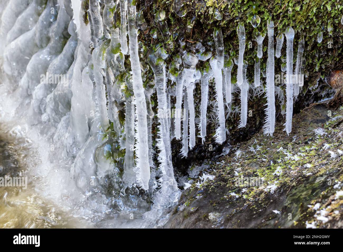 Frost and small icicles on a stone in the river. Spring thaw Stock ...