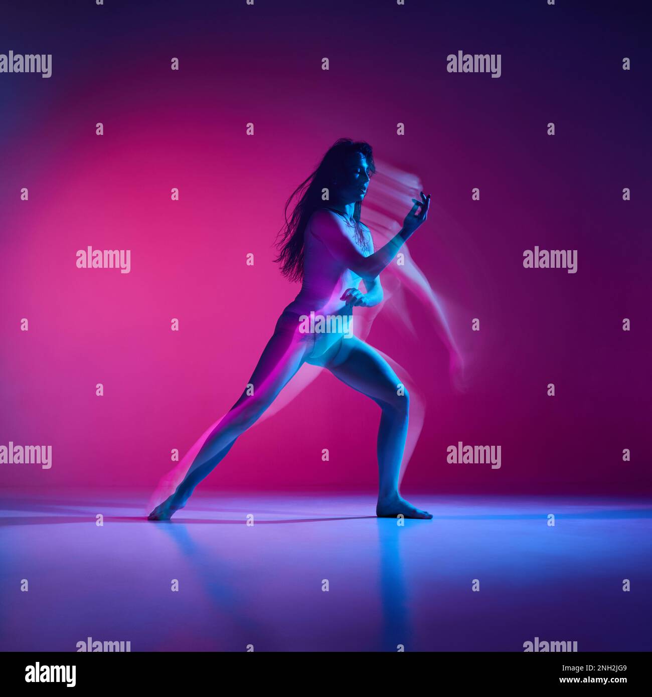 Feelings. Young woman dancing modern dance style over gradient pink ...