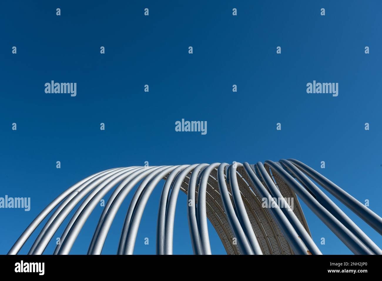 Aluminum tubes arching overhead against pure and deep blue sky Stock ...