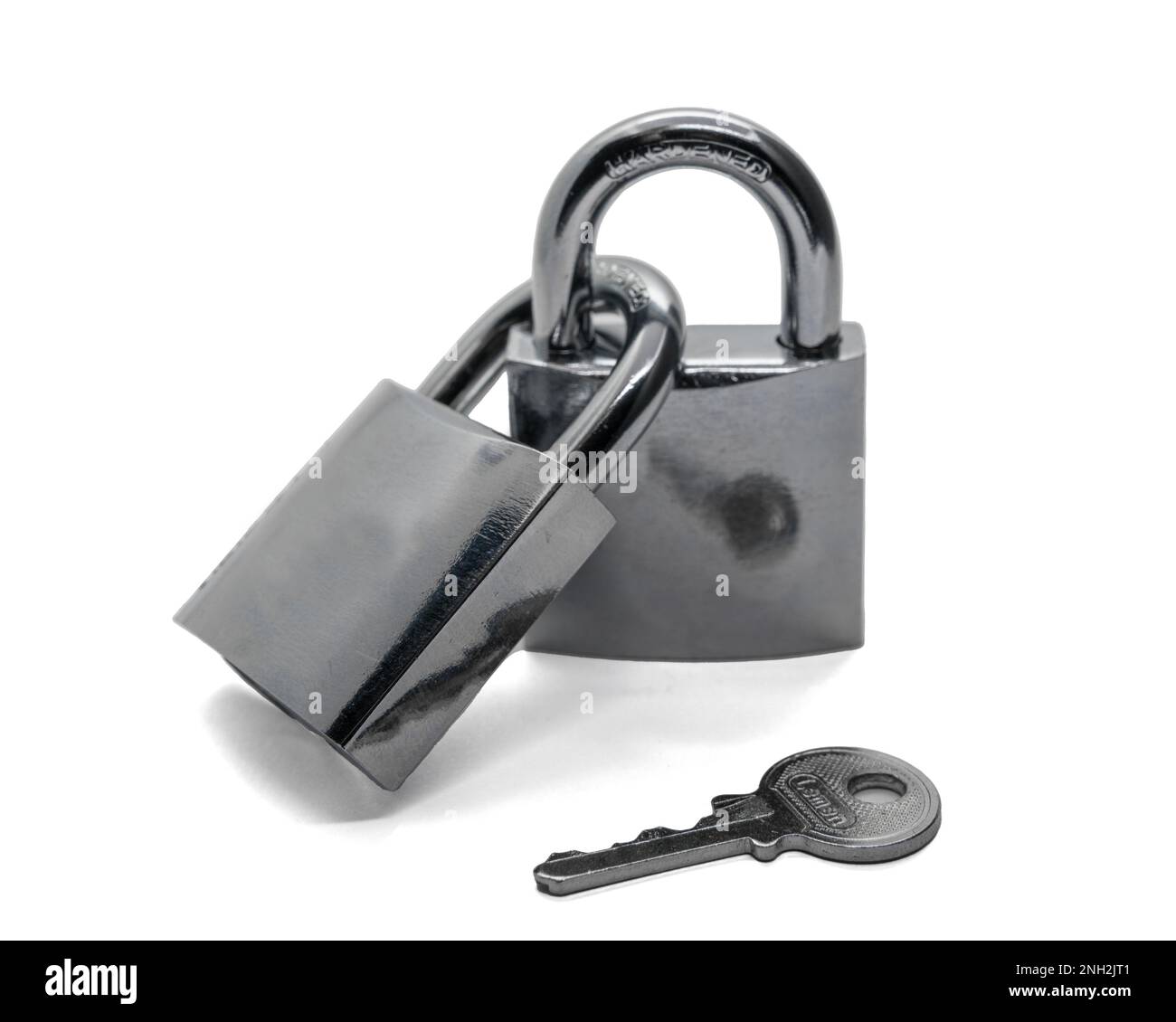 Two steel padlocks linked together and a key, isolated on white ...