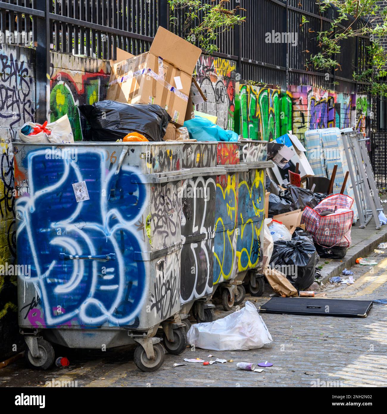 Dumpsters overflowing with rubbish and covered in grafitti Stock Photo ...