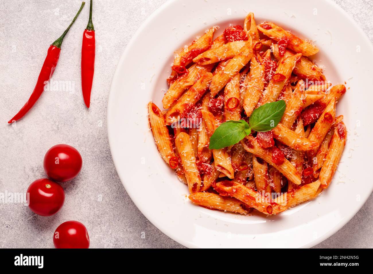 Classic italian pasta penne alla arrabiata with fresh basil on a light ...