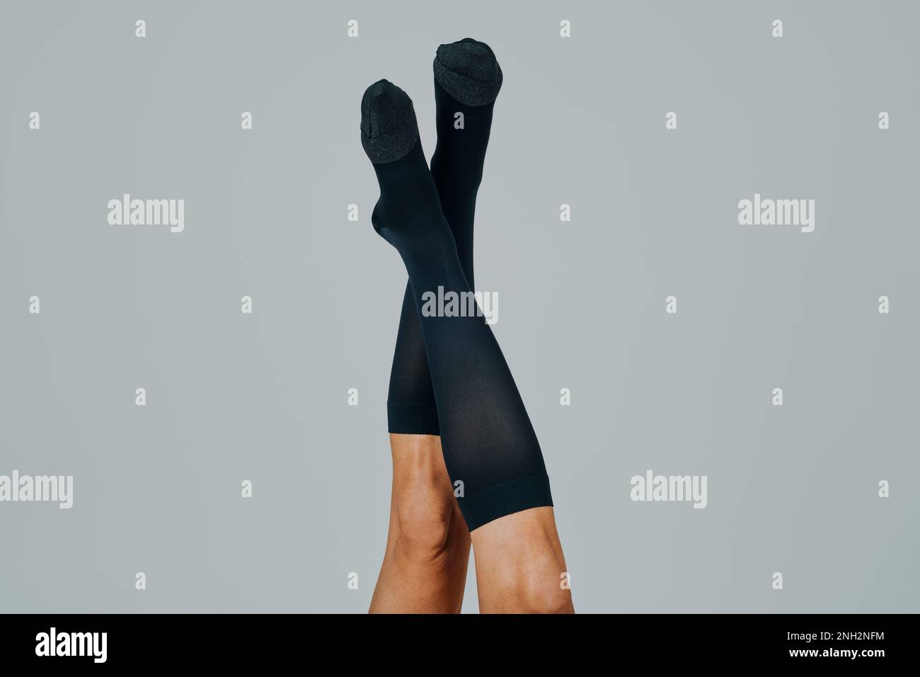 the legs of a man, upside down, wearing compression socks, in front of ...