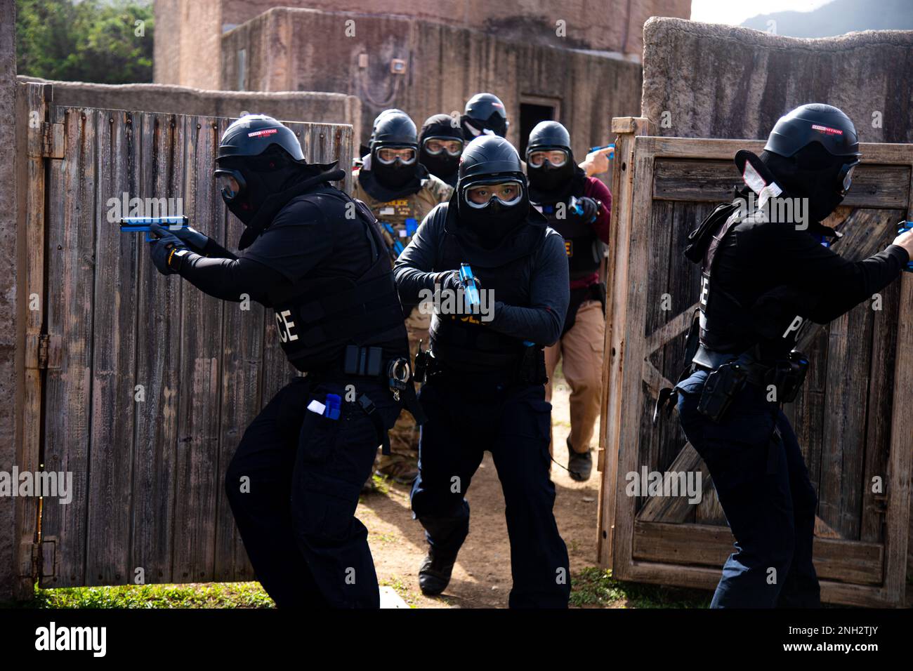 Officers with Honolulu Police Department enter an open area while ...