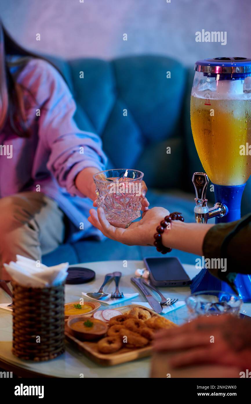 Hand of man giving glass with booze to girlfriend at party Stock Photo ...