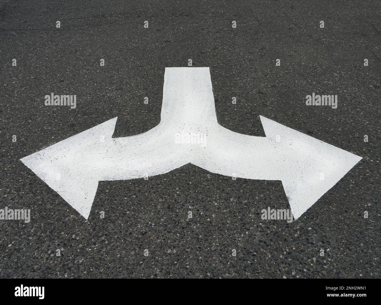 White traffic sign on gray asphalt. Turn left or right Stock Photo - Alamy