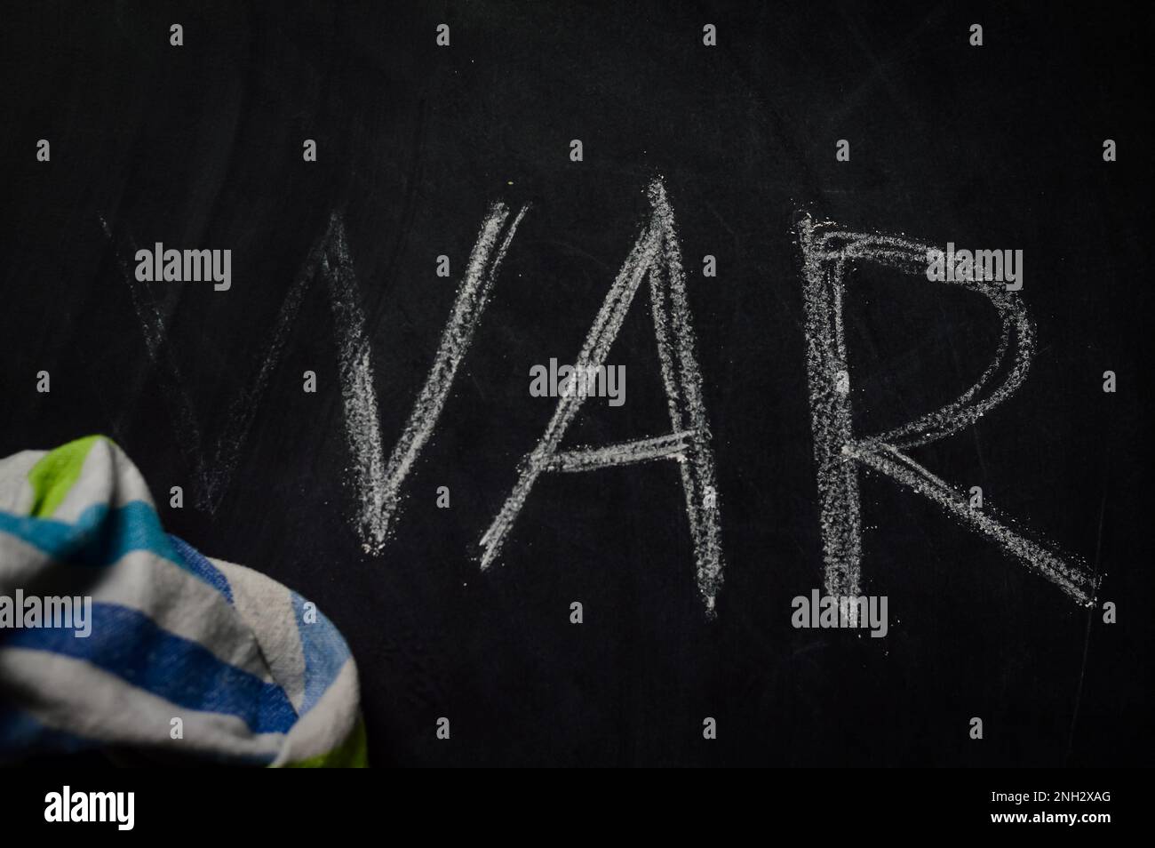 erasing war - rag wiping out the word war written with chalk on a ...
