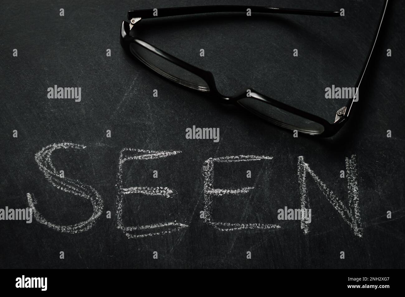 seen - word seen written in chalk on a blackboard with a pair of ...