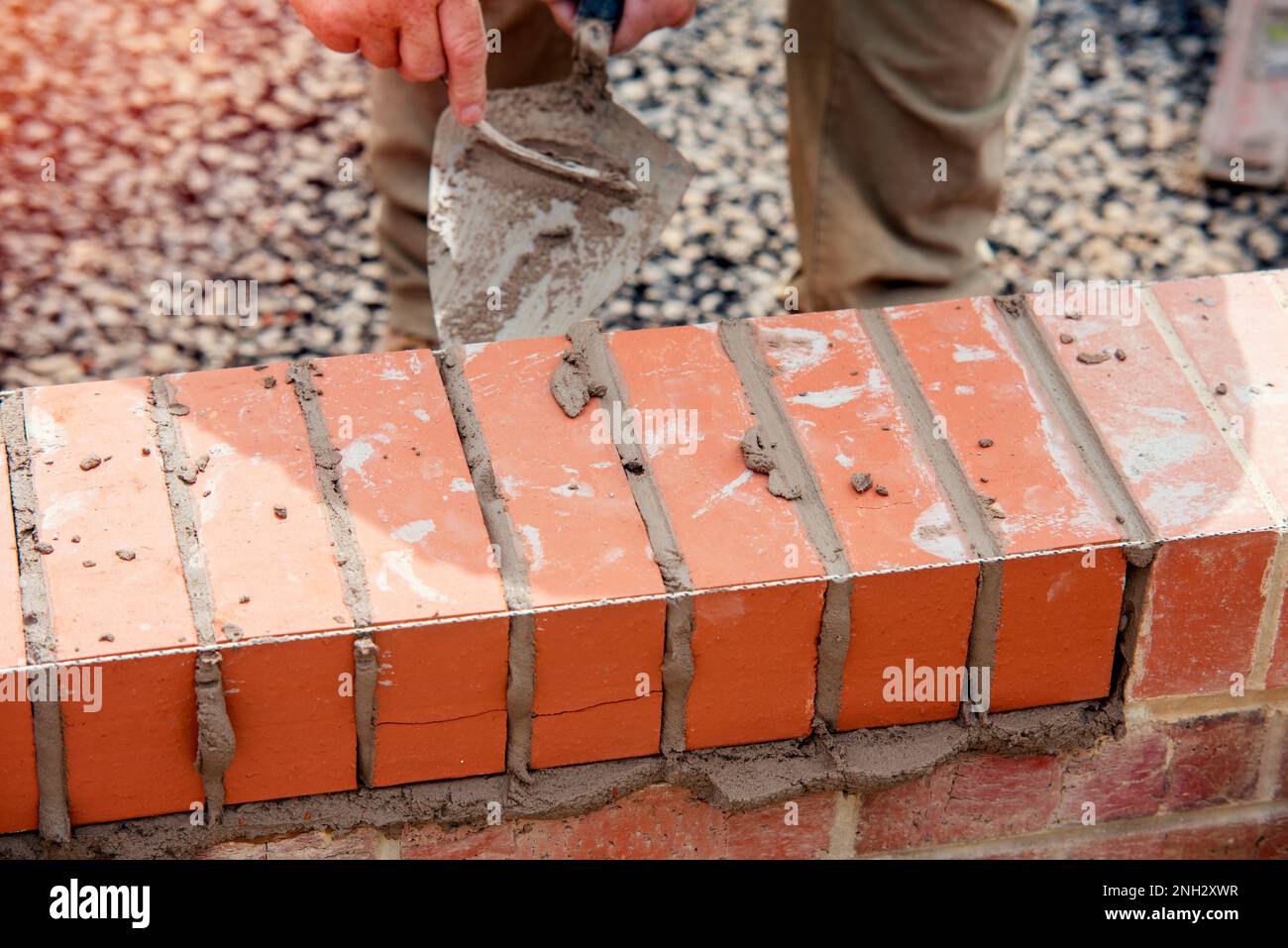 Close up of a brick wall and jointer trowel used by the worker to apply ...
