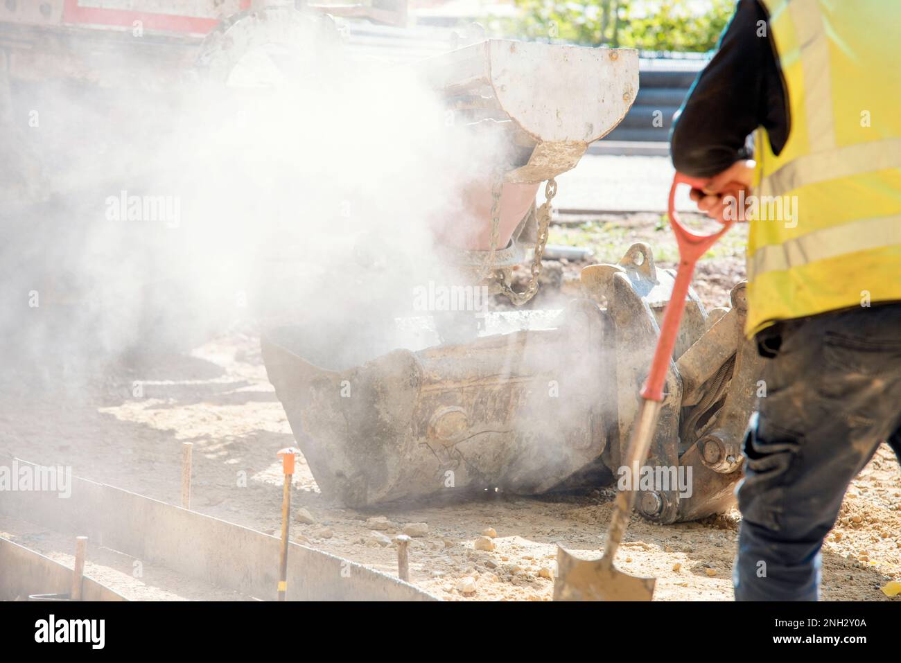 Excavator bucket filled with concrete to pour concrete into formwork on ... Excavator bucket filled with concrete to pour concrete into formwork on ...