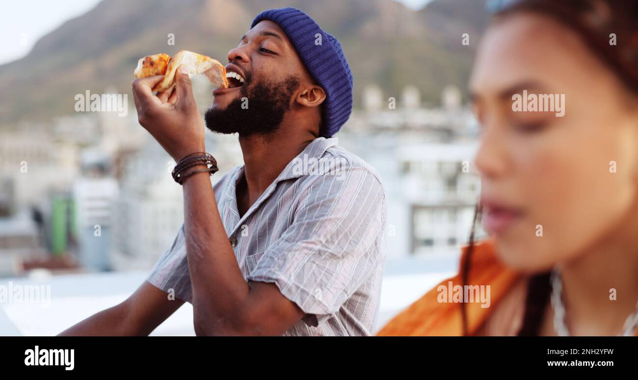 Couple, eating pizza and bonding on city building rooftop in Miami ...