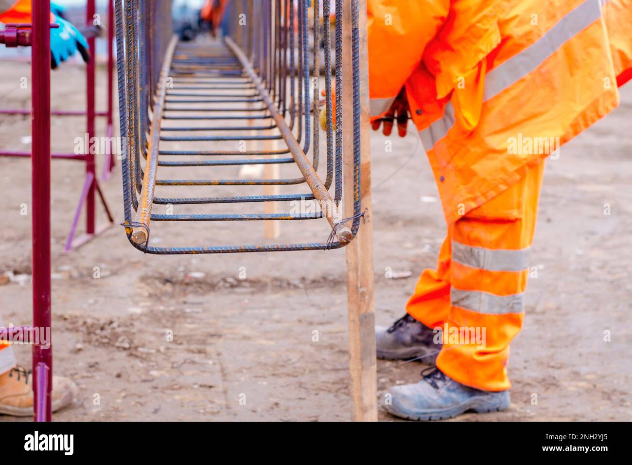 Builder's hands fixing steel reinforcement bars at construction site ...