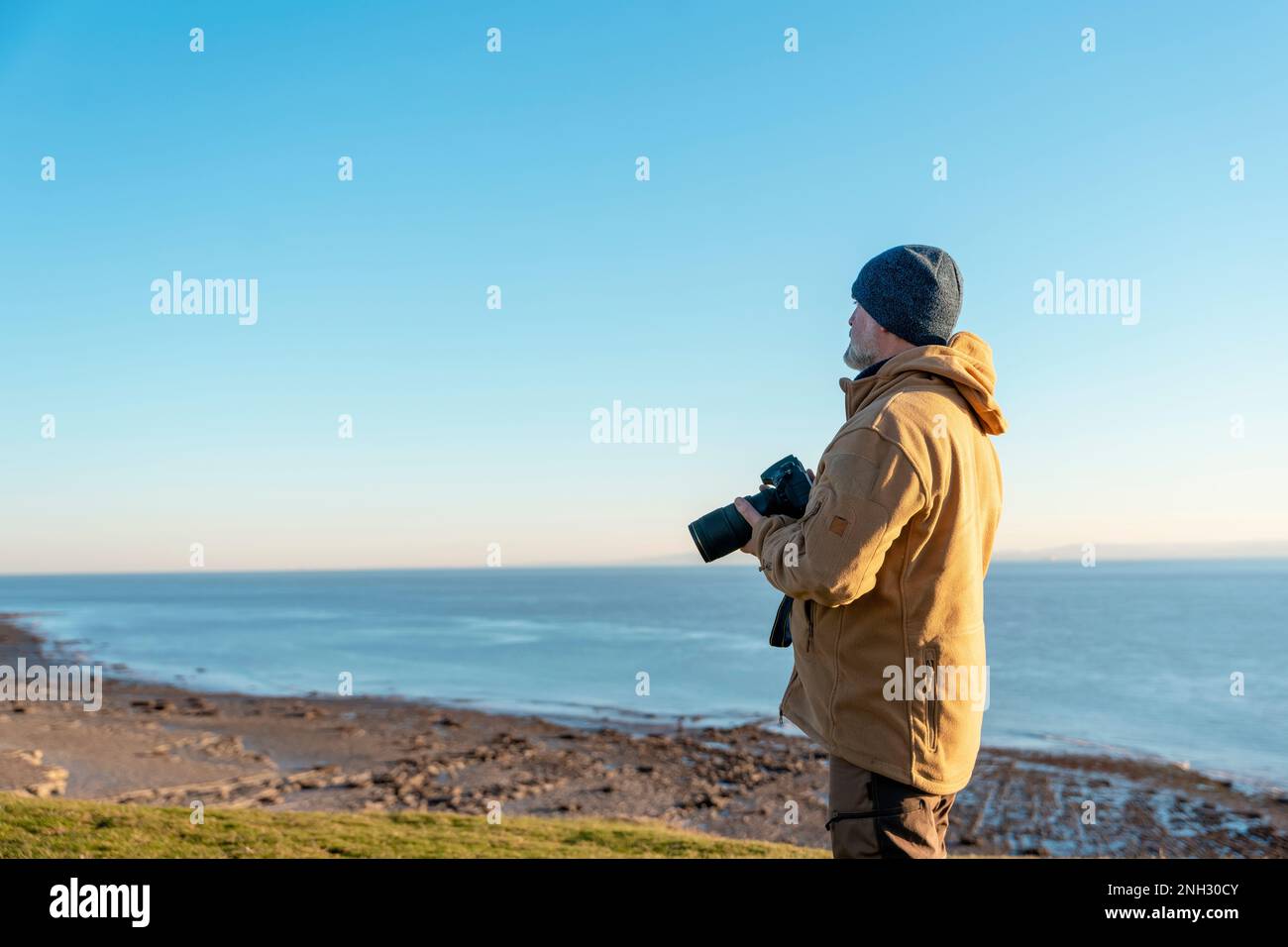 Bearded Man reaching the destination at sunset on cool day and taking ...