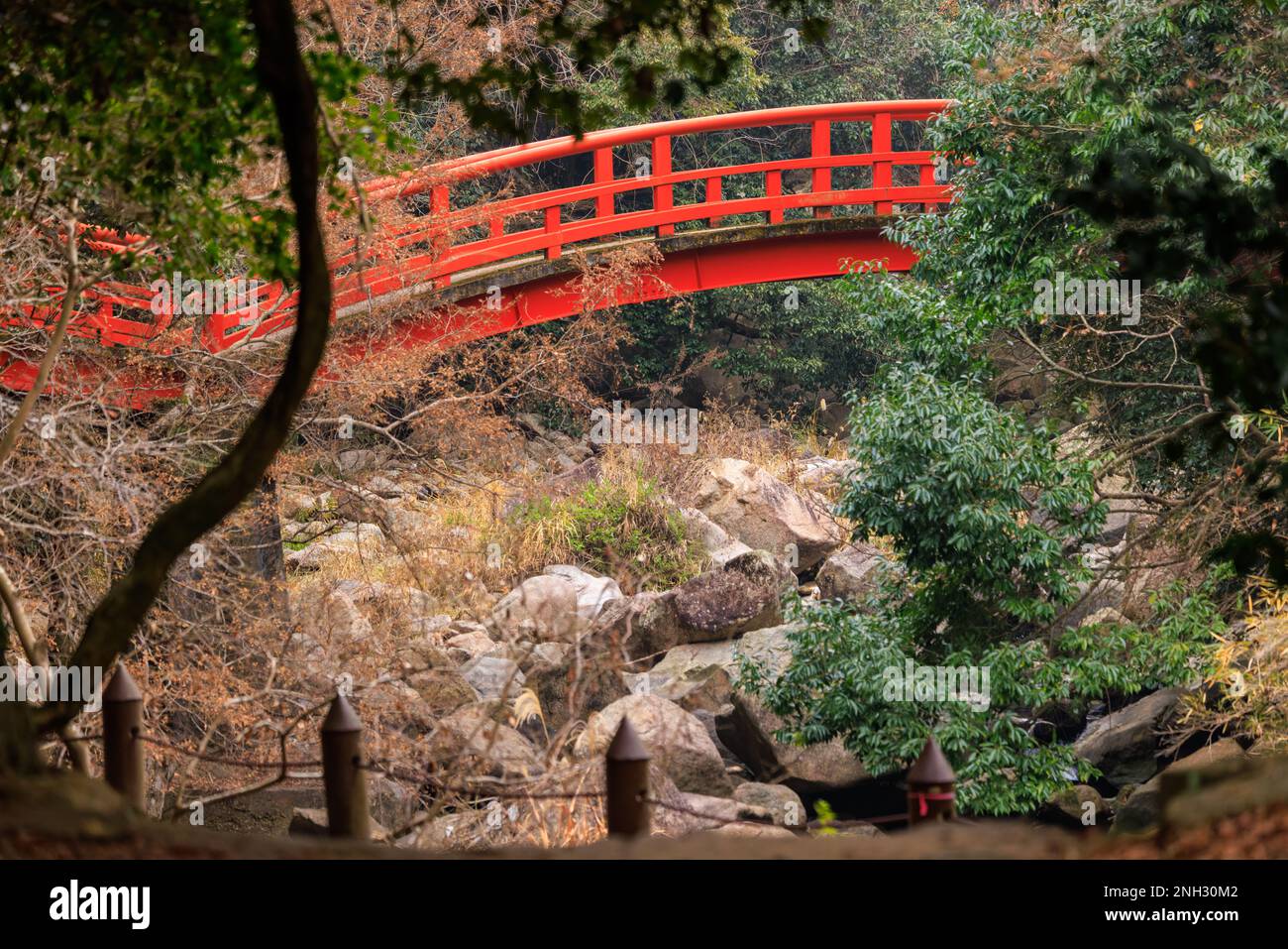 Arched red bridge over dry rocky river in quiet forest Stock Photo - Alamy