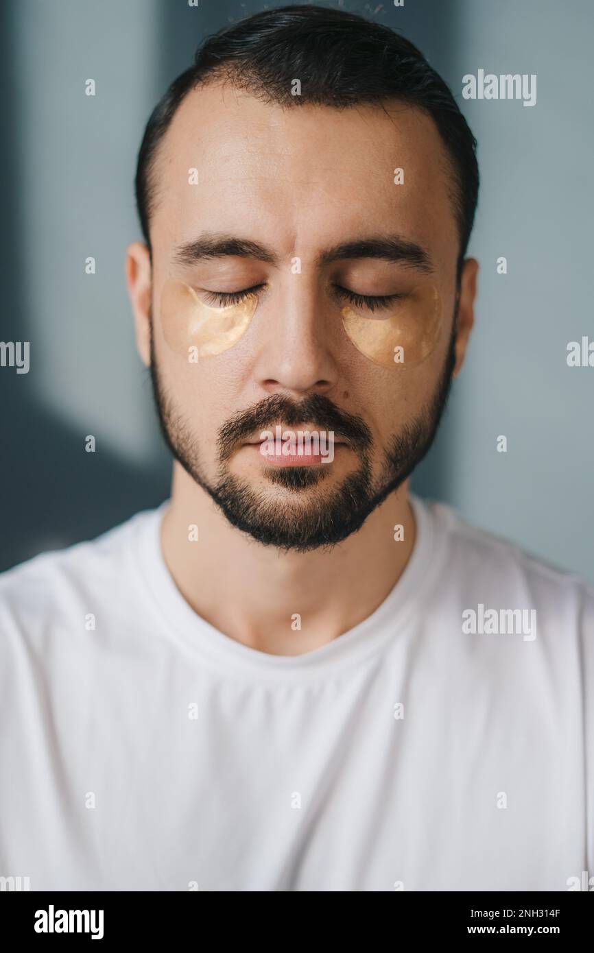 Relaxed bearded man with under eye patches and eyes closed, isolated ...