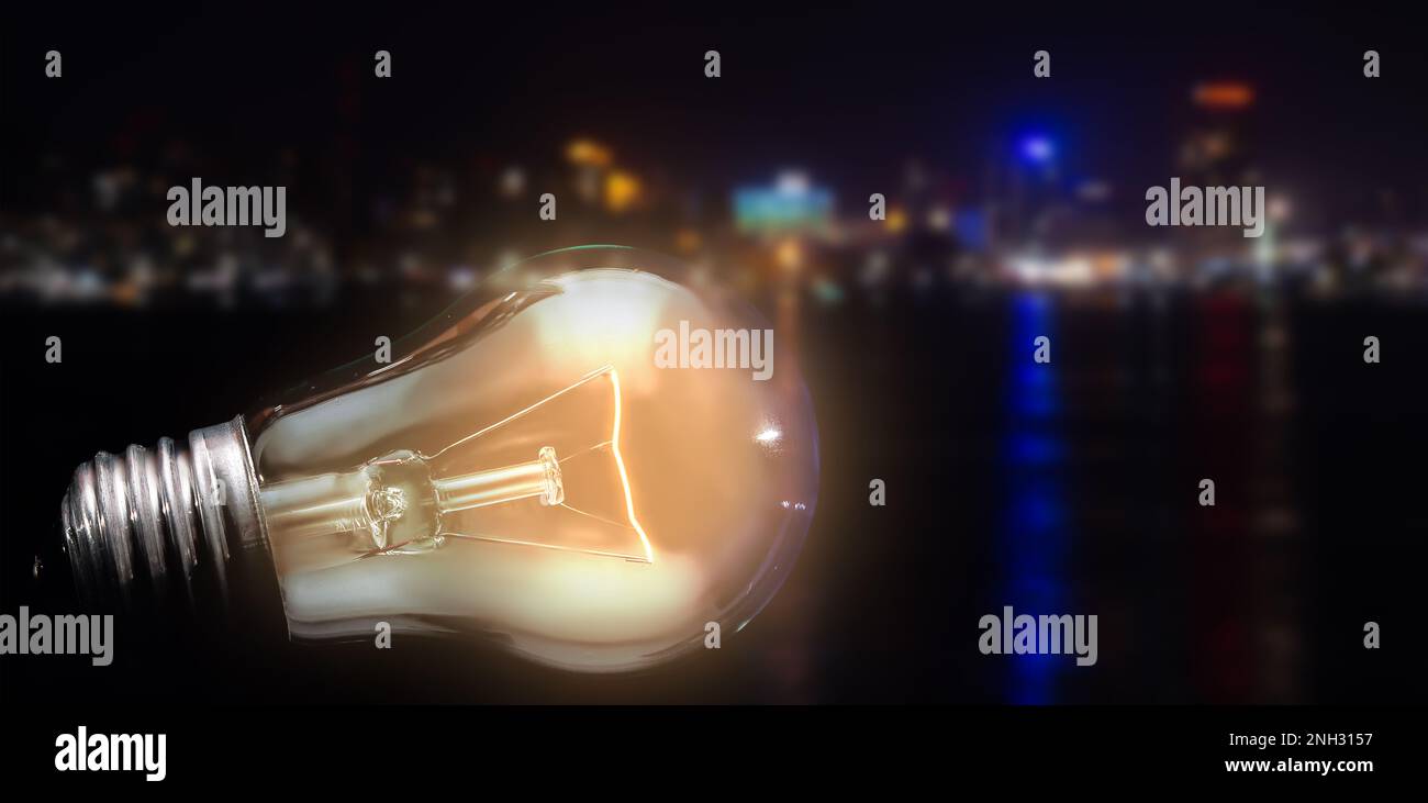 close up of tungsten light bulb with glow on dark background and night ...