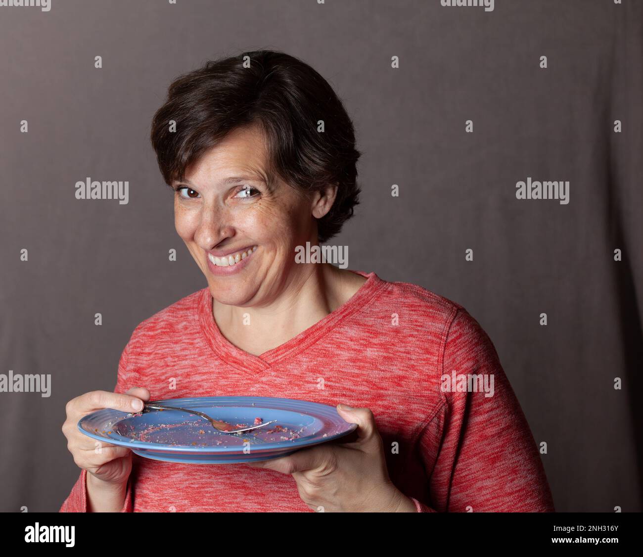 Older woman with an empty blue plate Stock Photo - Alamy