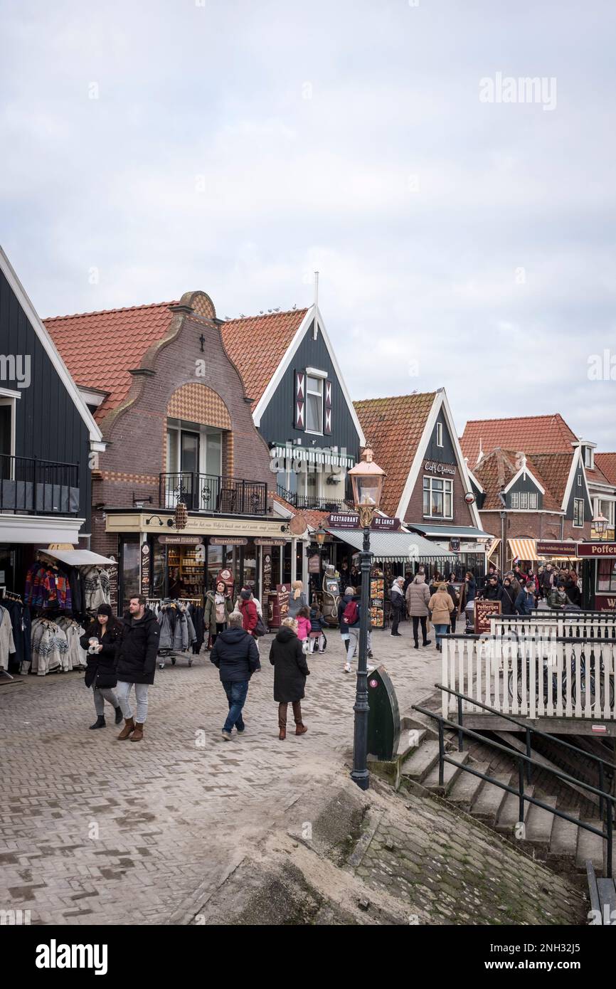 Tourists walk by shops on the waterfront promenade in the winter, in ...