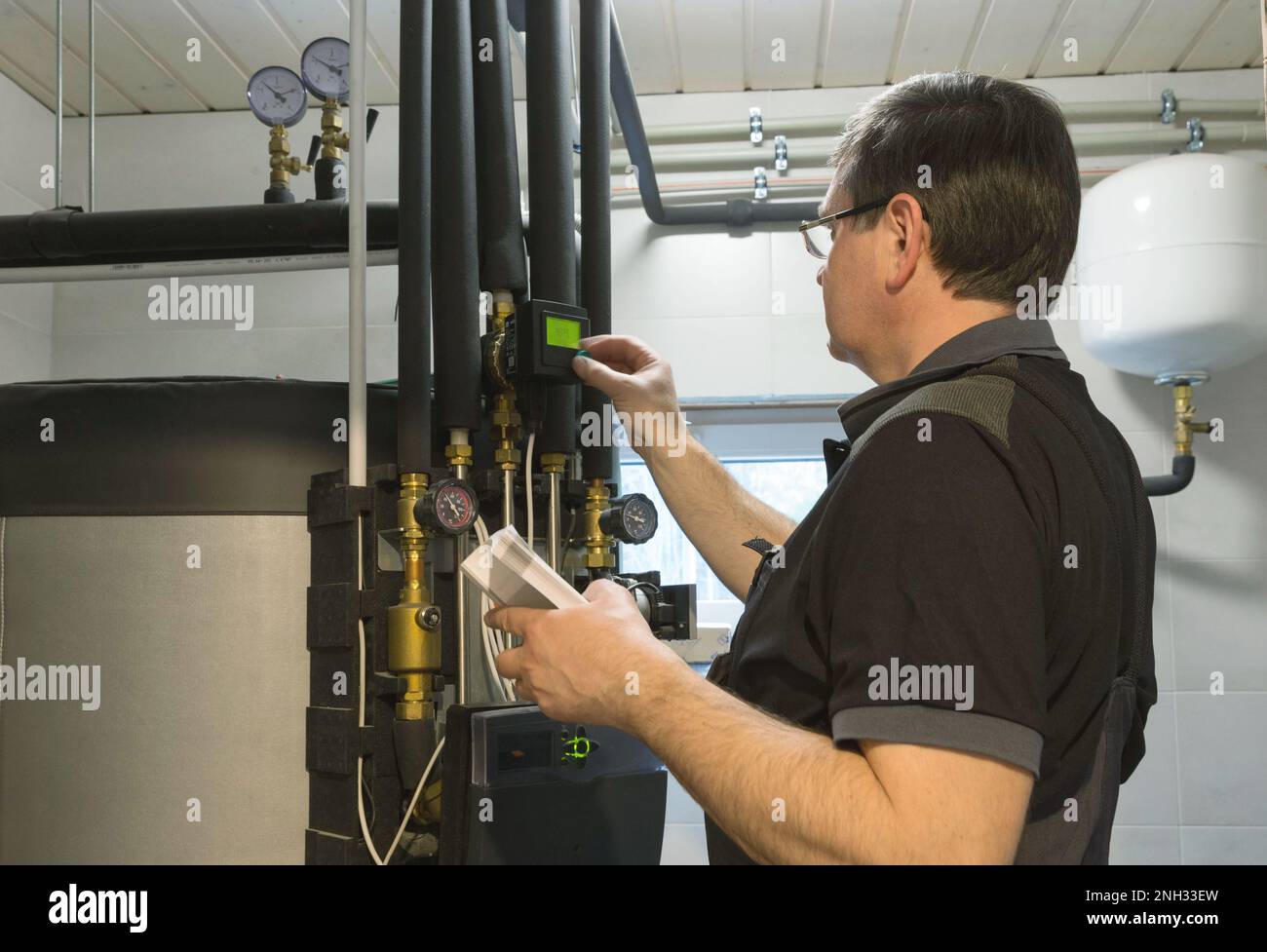 Technician checks the heating system in the boiler room in private ...