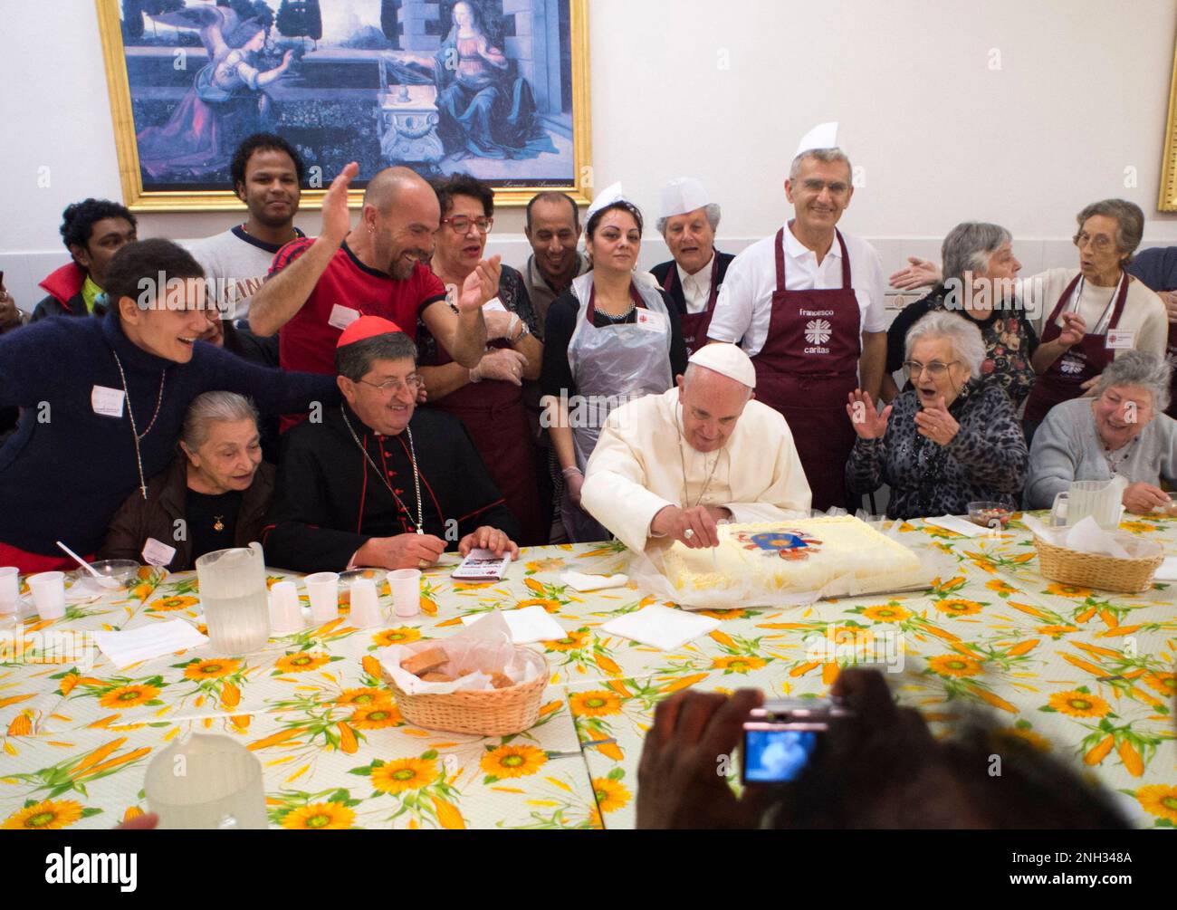 Pope Francis cuts a cake after he ate his lunch on a plastic plate at ...