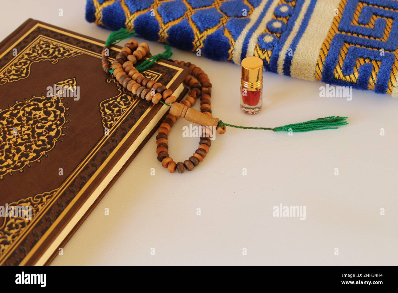 Holy quran and prayer rosary on prayer mat on white background. Islamic ...