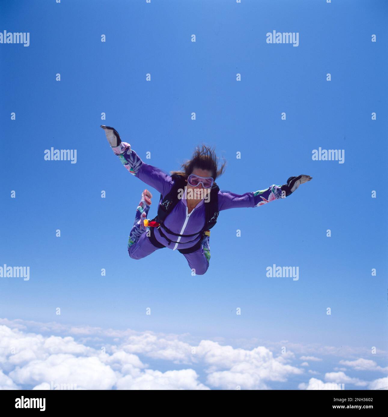 Single skydiver freefalling above the clouds. Prior to shute opening ...