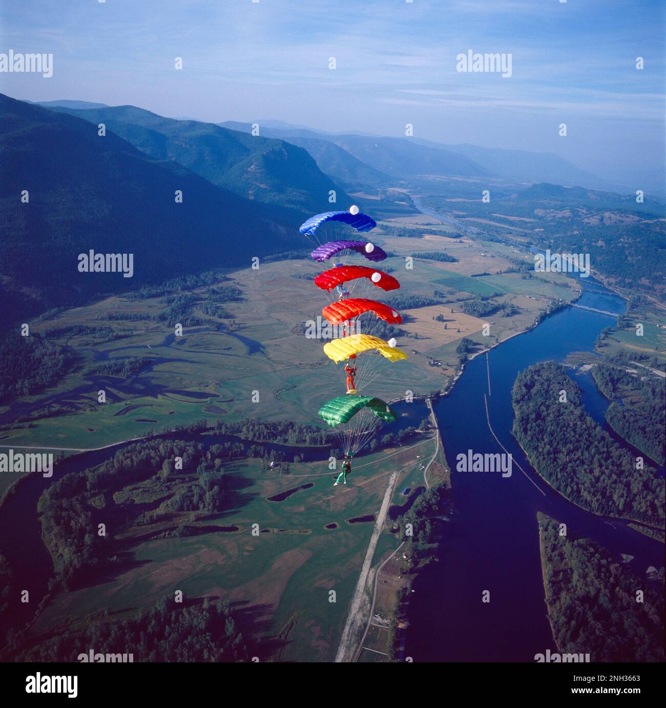 Aerial view of six skydivers falling to earth with their parachutes ...