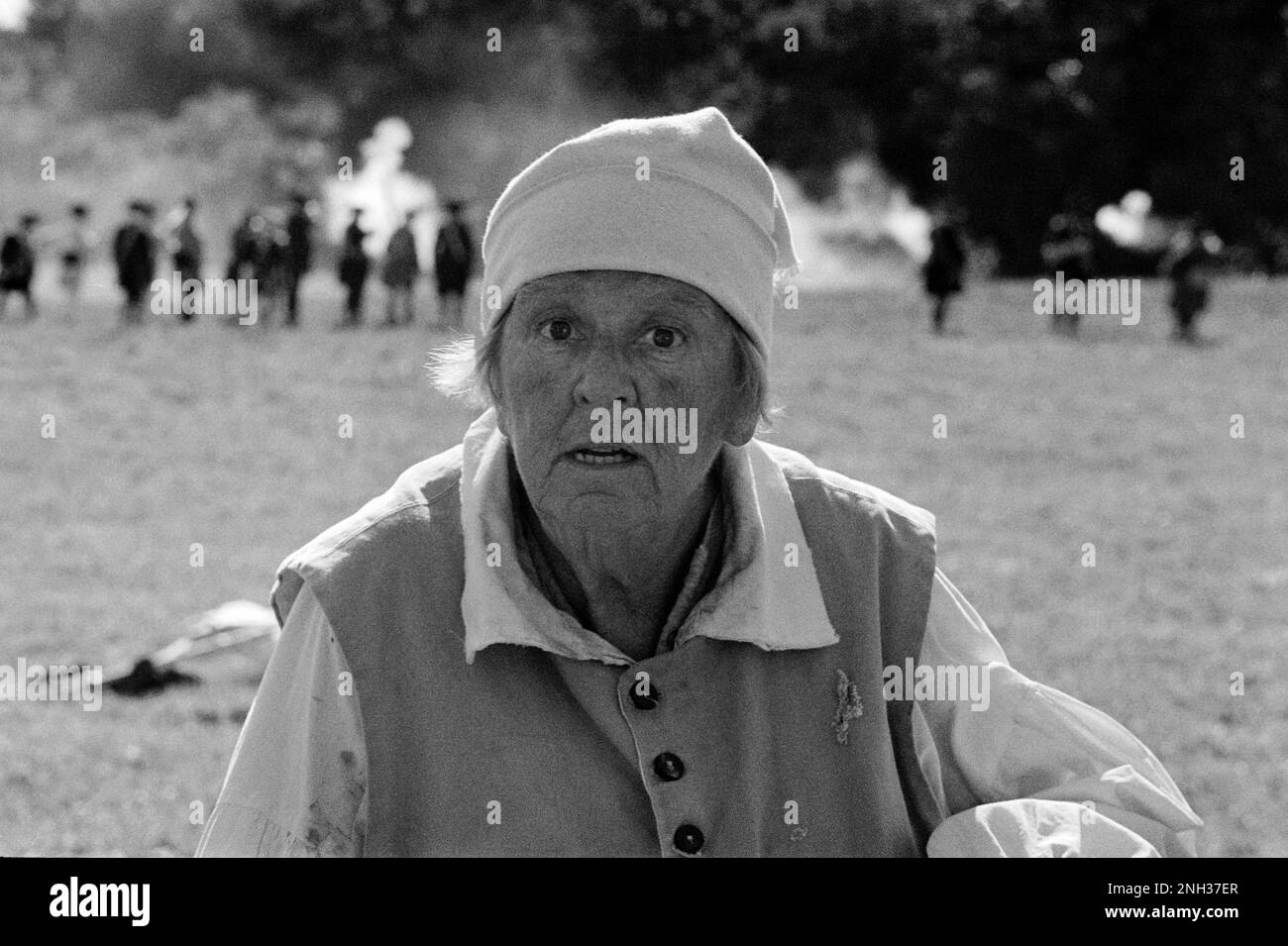 An elderly woman collects the clothing and personal belonging from dead ...