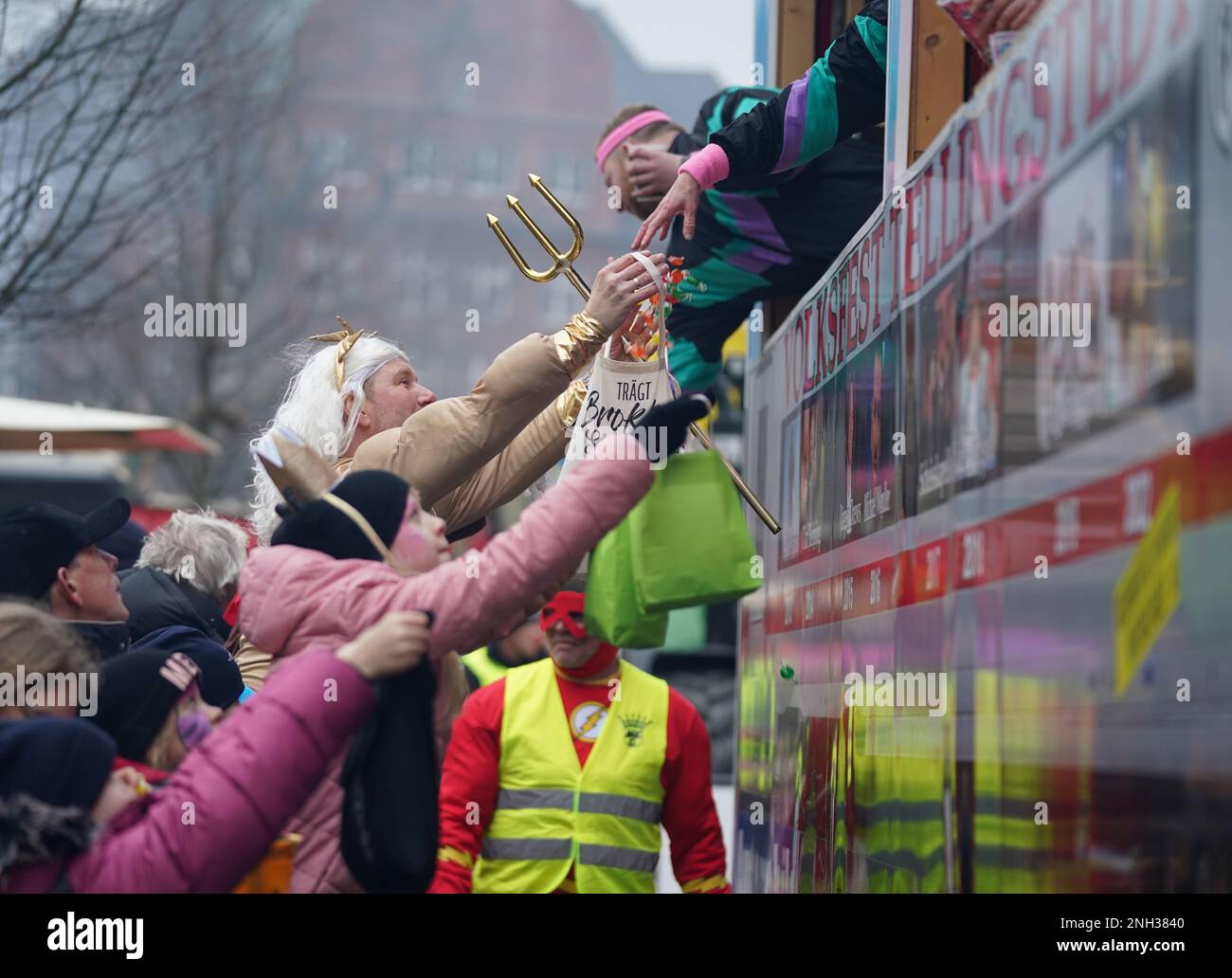 Marne, Germany. 20th Feb, 2023. Passers-by try to catch the Kamelle ...