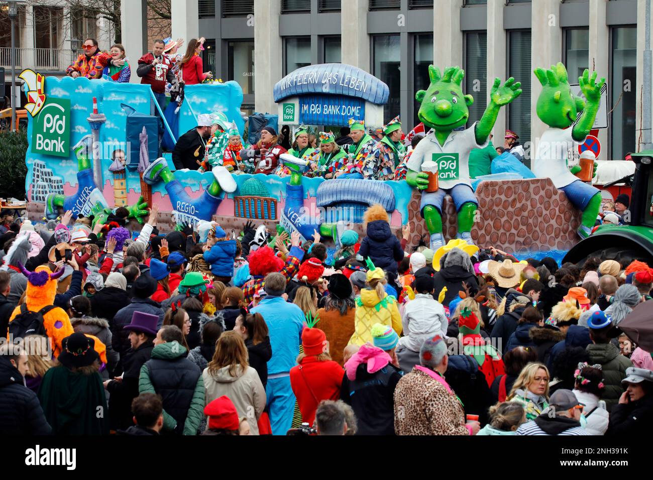 Crowds of many masked revelers cheer the Rose Monday parade in ...