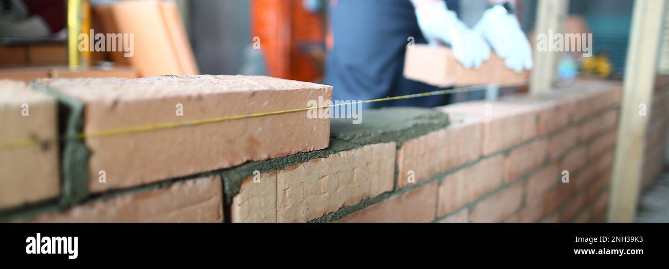 Professional builder lays bricks and builds a wall in apartment Stock ...