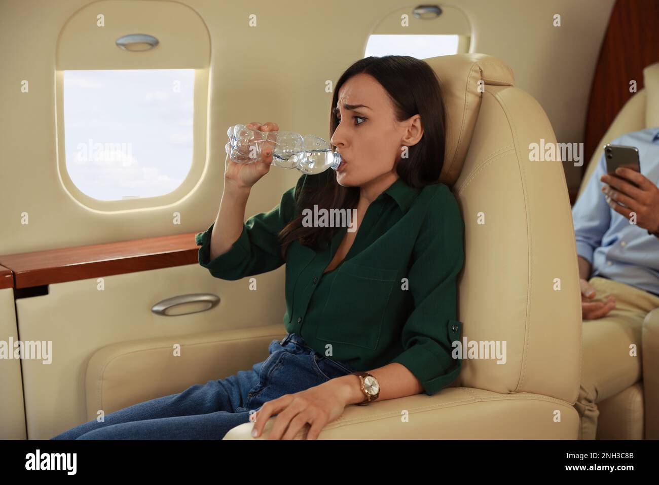 Nervous young woman with aviophobia drinking water in airplane Stock ...