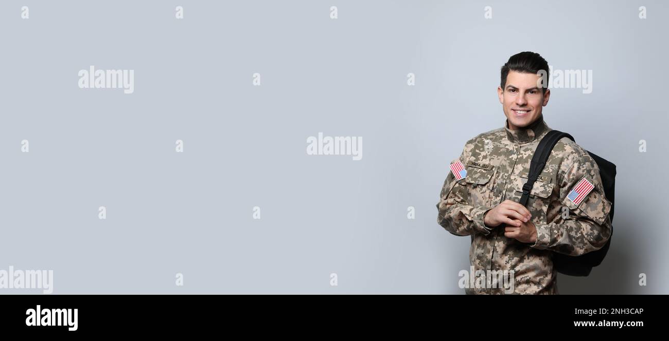 Cadet with backpack on light grey background. Military education Stock ...