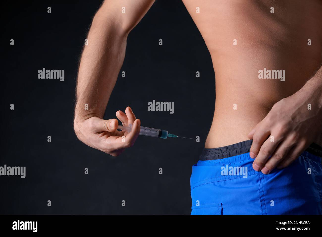 Man injecting himself on black background, closeup. Doping concept ...