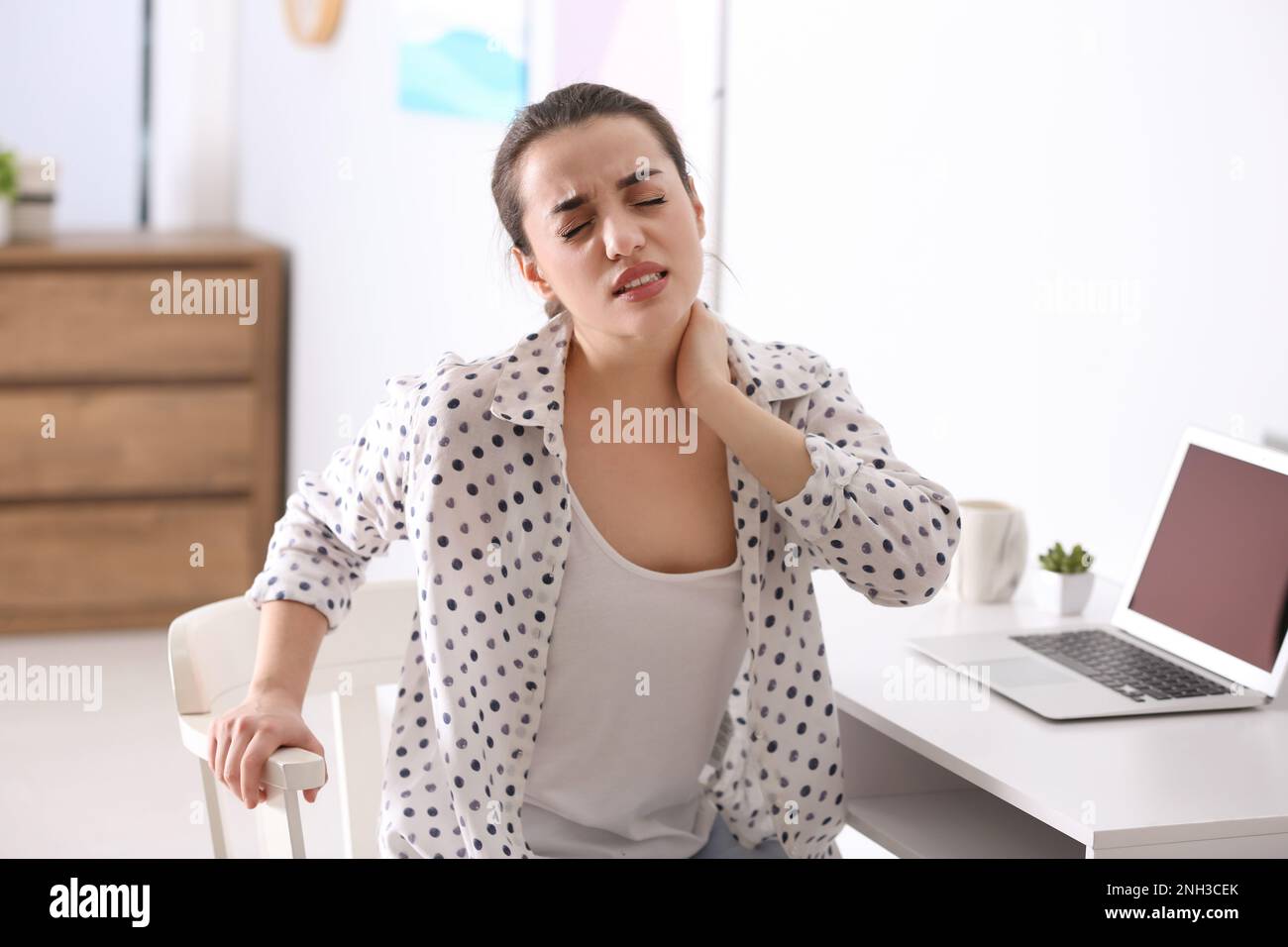 Woman suffering from neck pain in office. Bad posture problem Stock ...