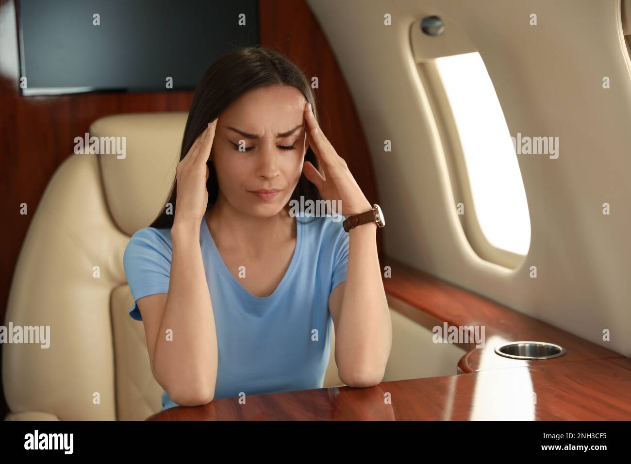 Young woman feeling bad during flight in airplane Stock Photo - Alamy