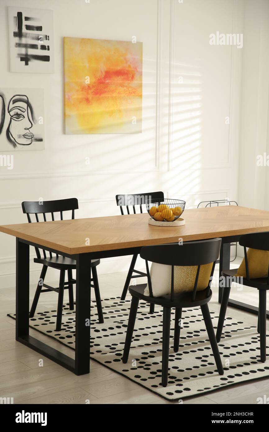Stylish wooden dining table and chairs in room. Interior design Stock ...