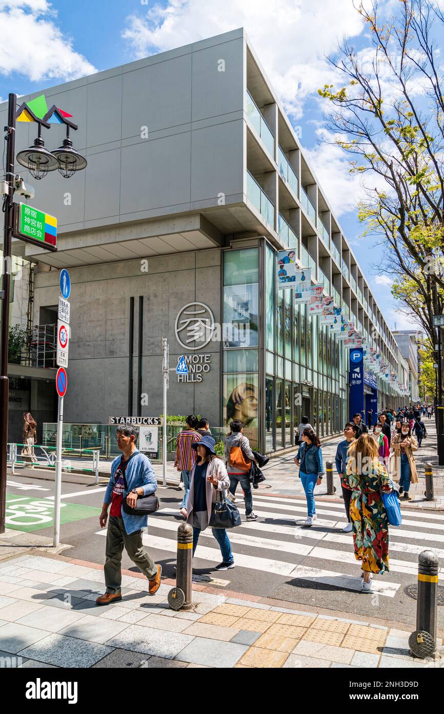 Tokyo. Daytime view along pavement crowded with people walking and ...