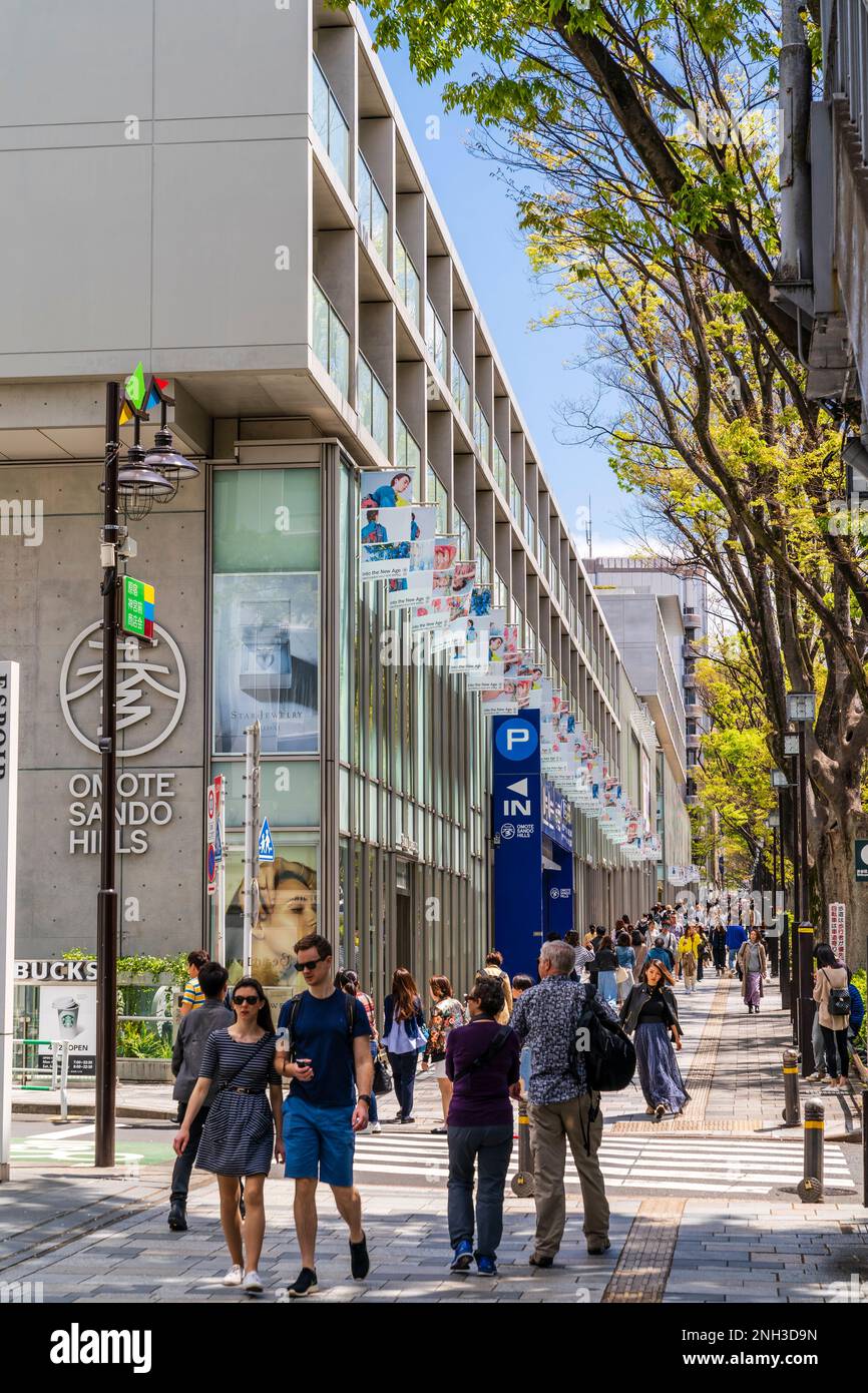 Tokyo. Daytime view along pavement crowded with people walking and ...