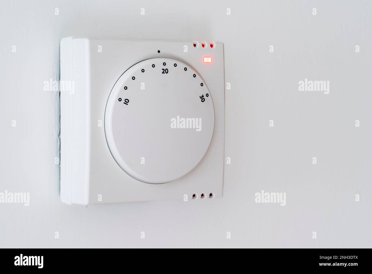 Household white central heating electric thermostat on white wall set ...