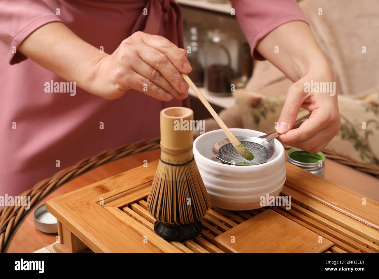Master preparing matcha drink at wooden table, closeup. Tea ceremony ...